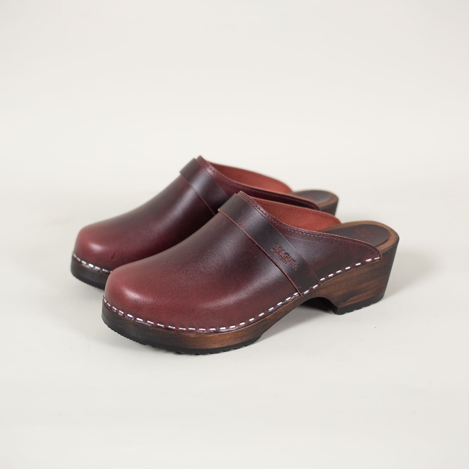 Berkeley clogs in bordeaux pull up leather on a brown wooden bottom