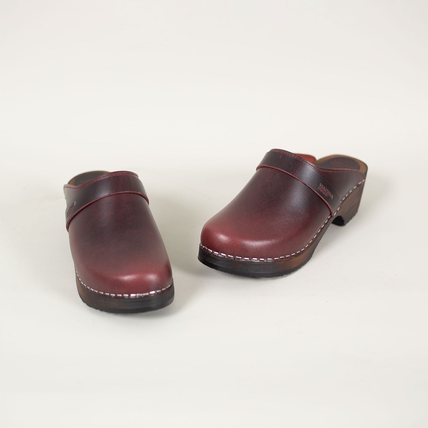 Berkeley clogs in bordeaux pull up leather on a brown wooden bottom