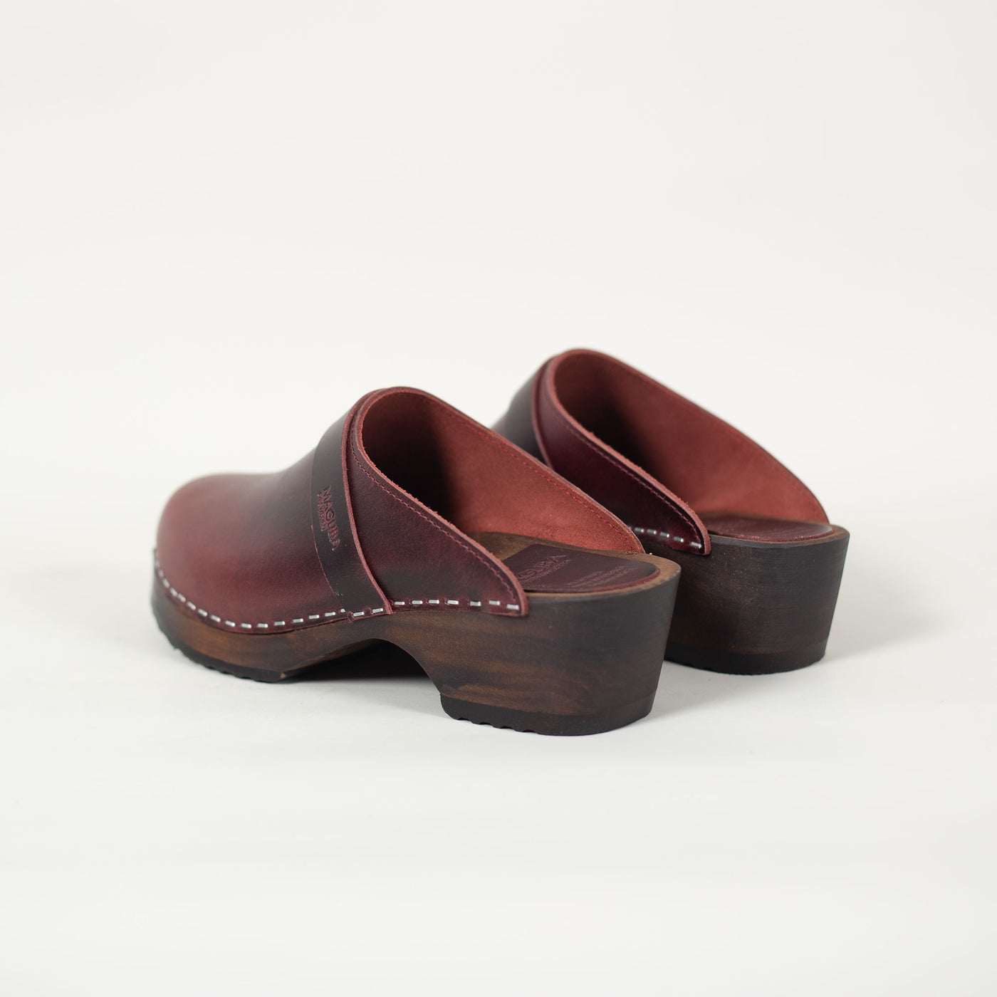 Berkeley clogs in bordeaux pull up leather on a brown wooden bottom
