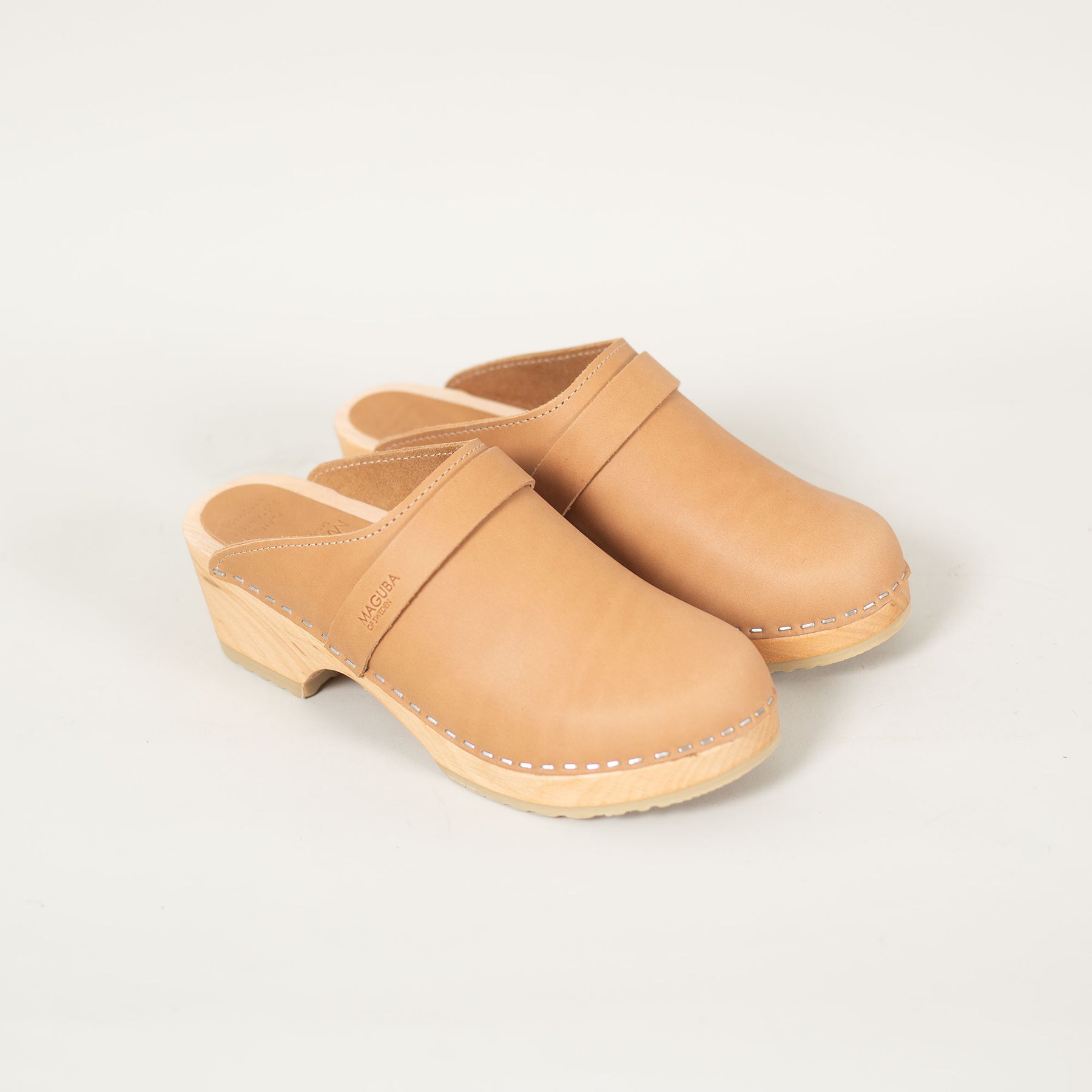 Berkeley clogs in light tan leather on a natural wooden bottom