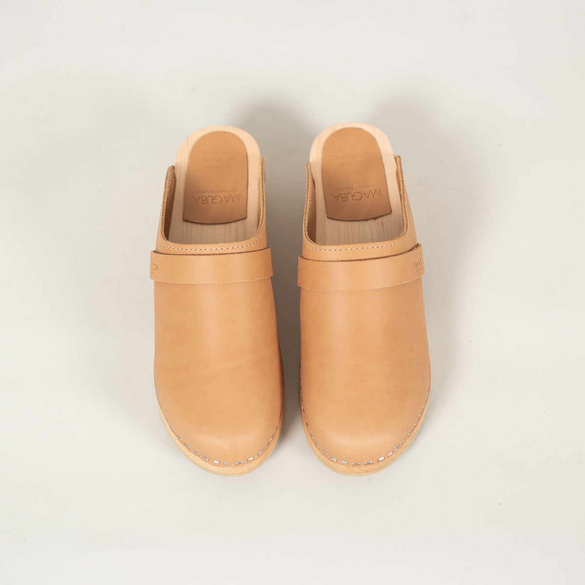 Berkeley clogs in light tan leather on a natural wooden bottom